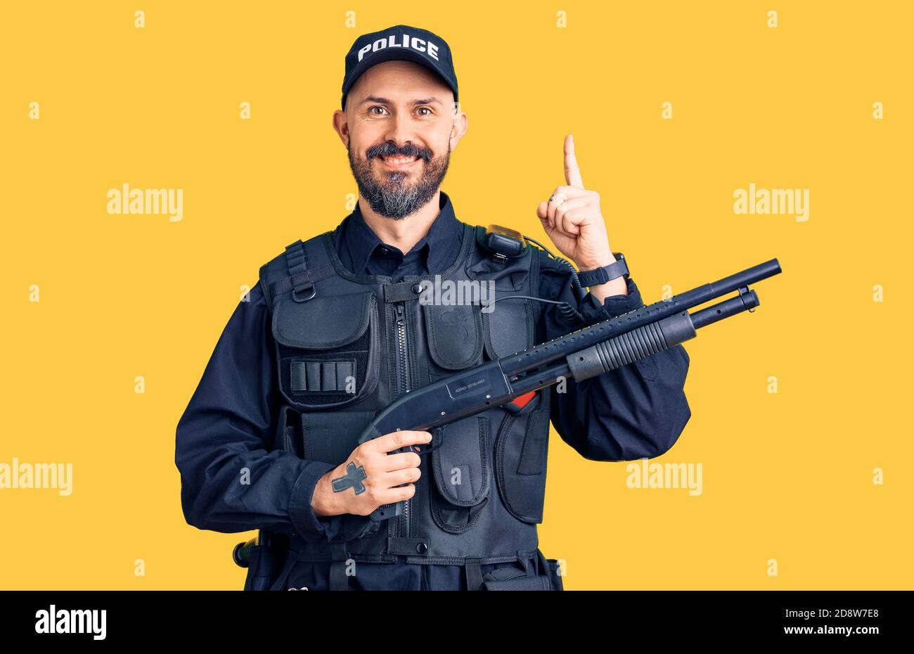 Young handsome man wearing police uniform holding shotgun surprised ...