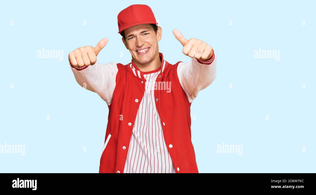 Handsome caucasian man wearing baseball uniform approving doing ...
