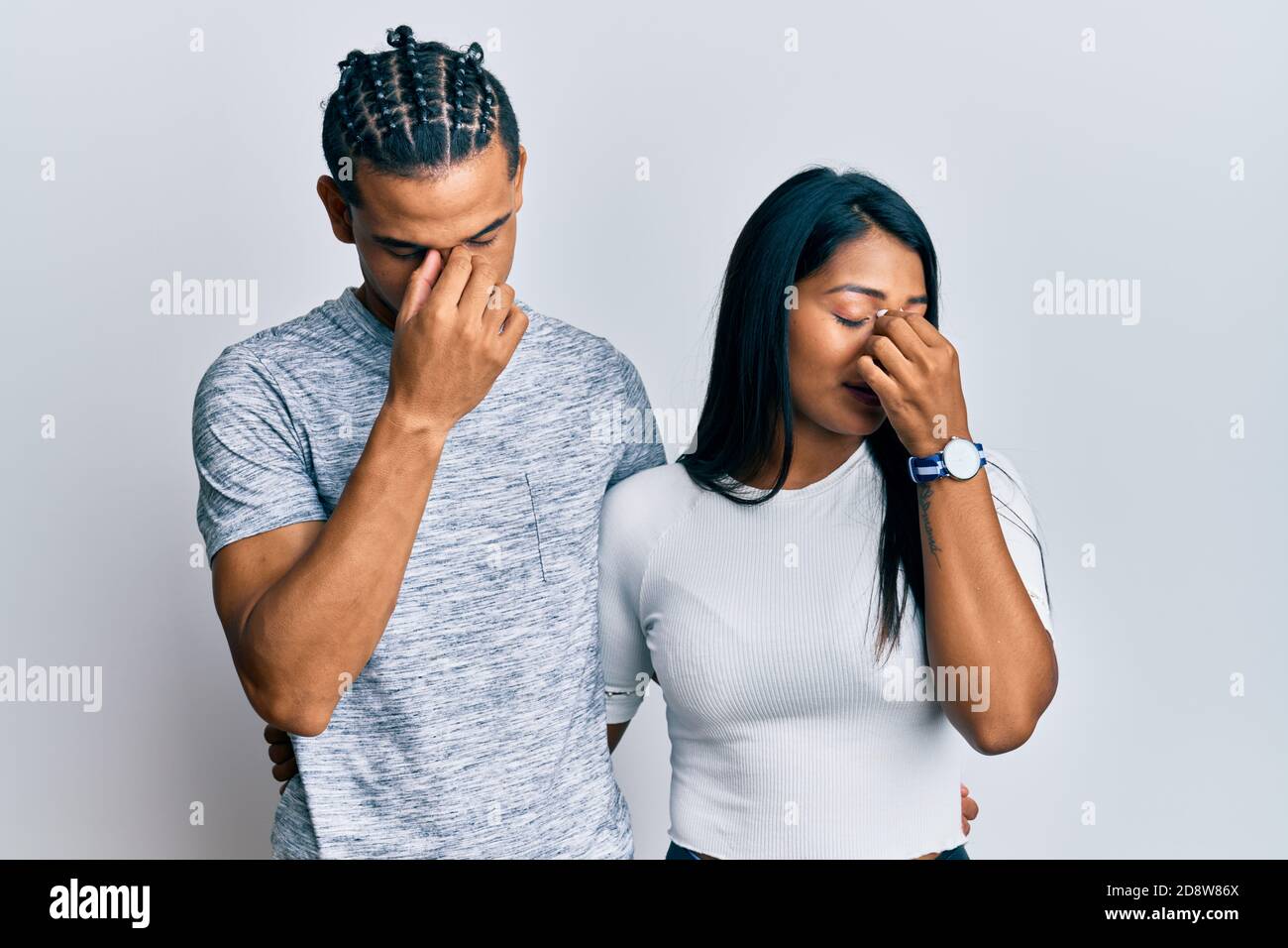 Young latin couple wearing casual clothes tired rubbing nose and eyes ...