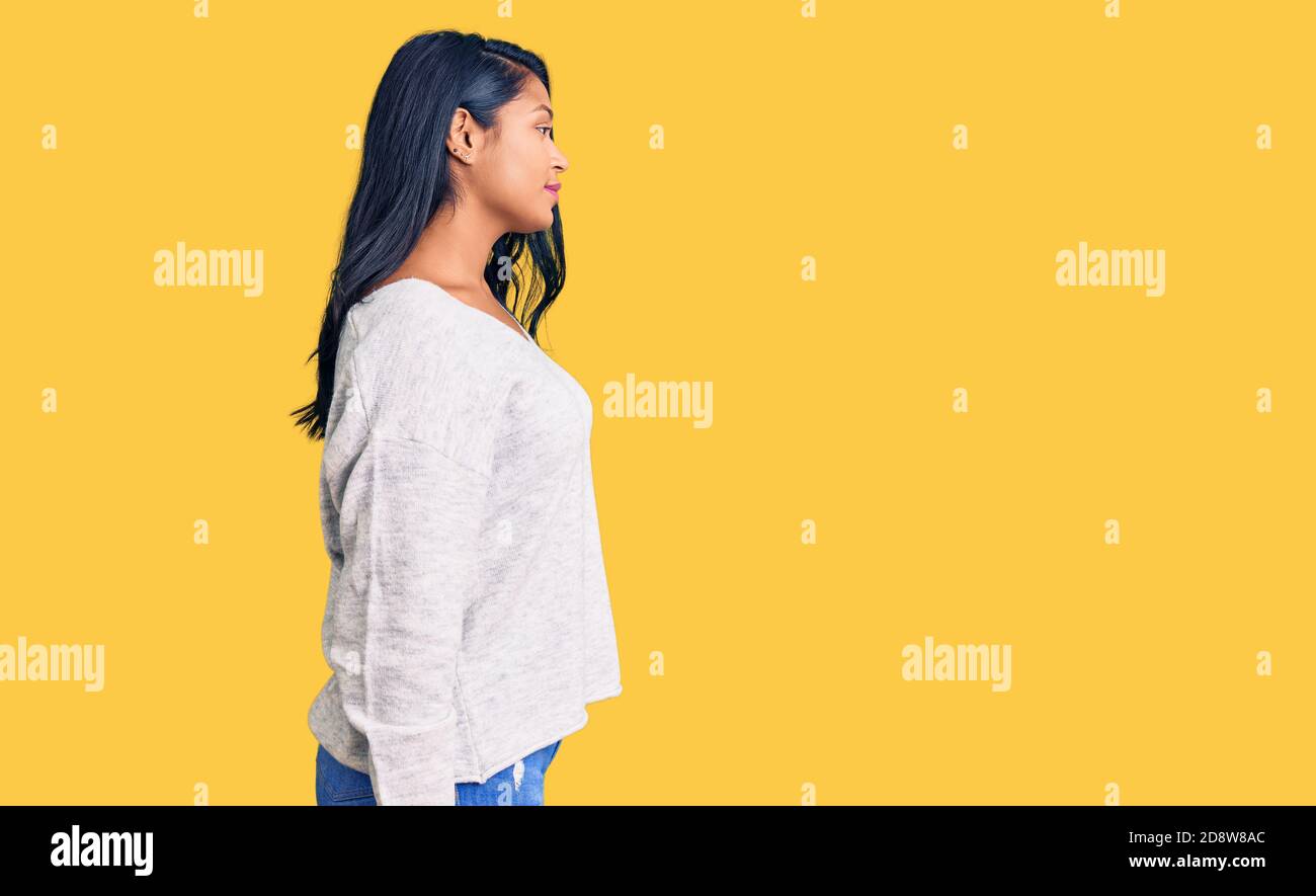 Hispanic woman with long hair wearing casual clothes looking to side ...
