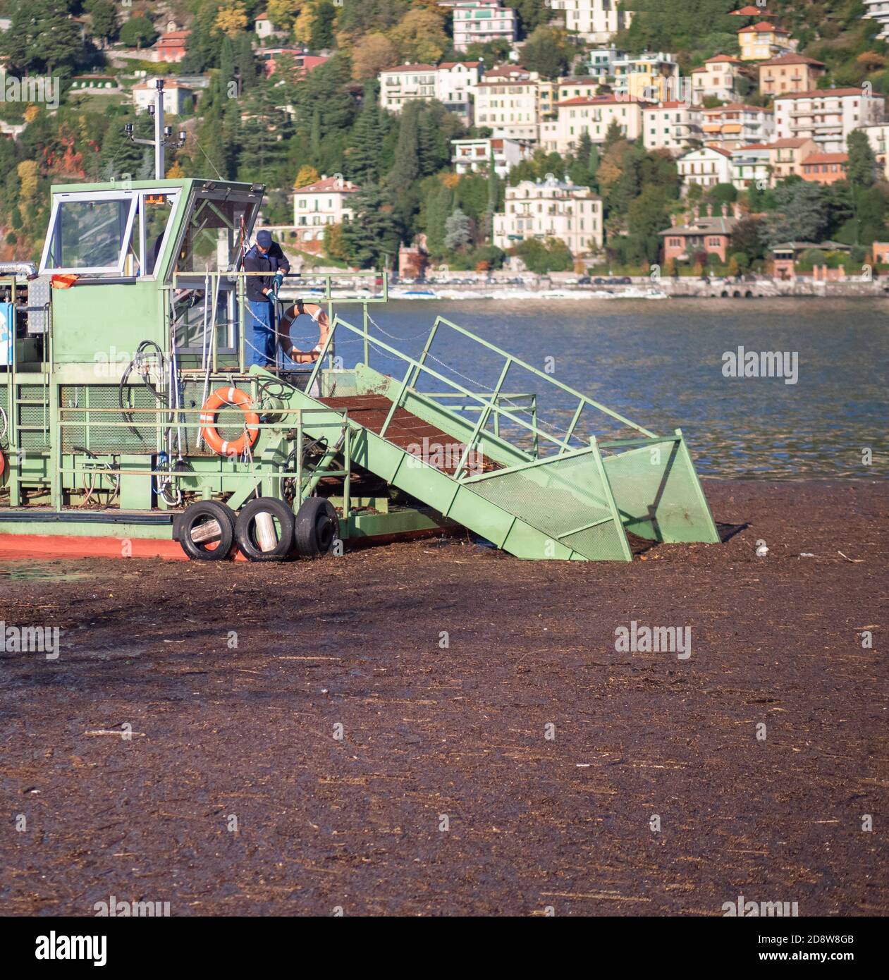 cleaning the lake surface with a sweeper ship from plastic waste and ...