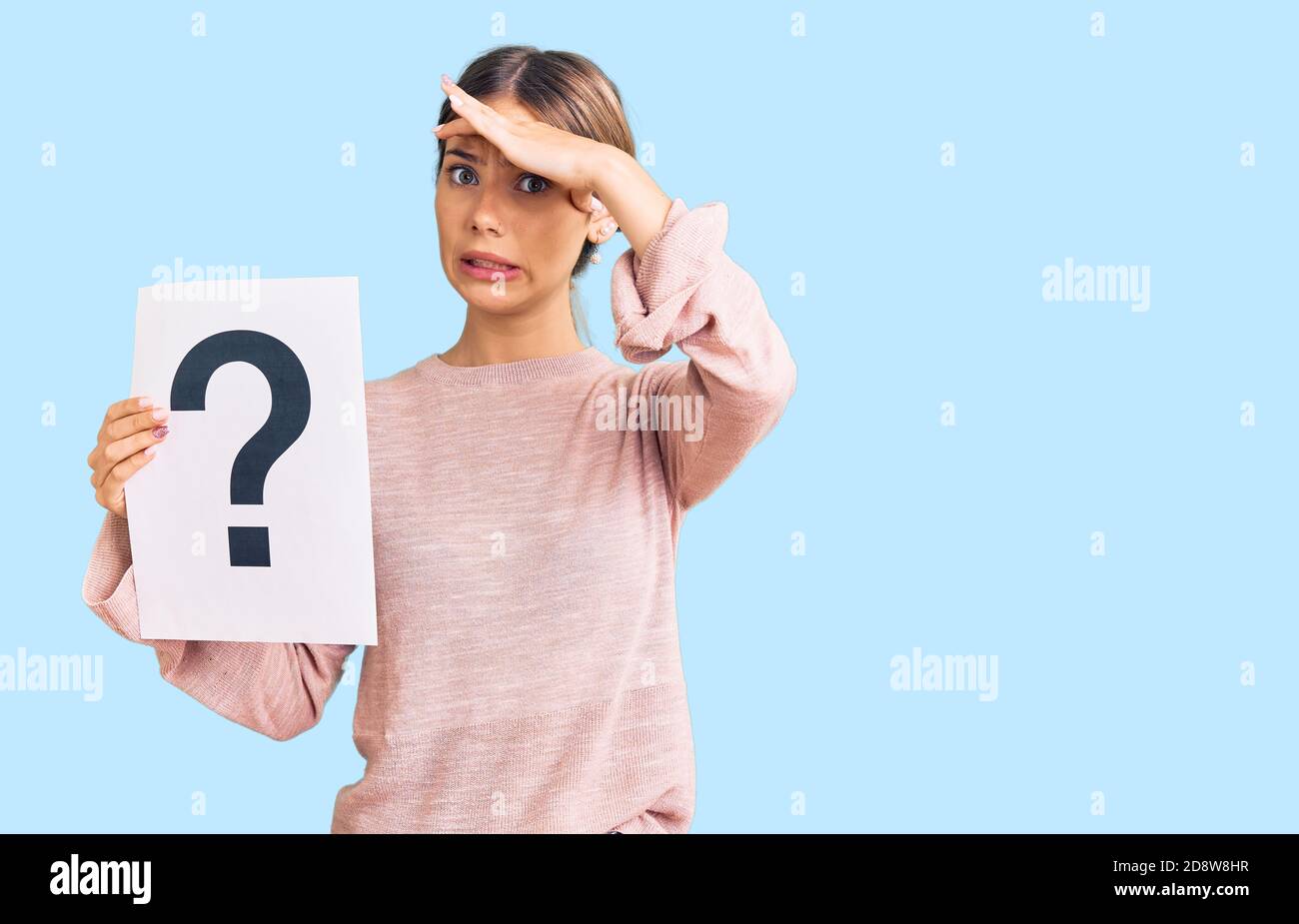 Beautiful caucasian woman with blonde hair holding question mark ...