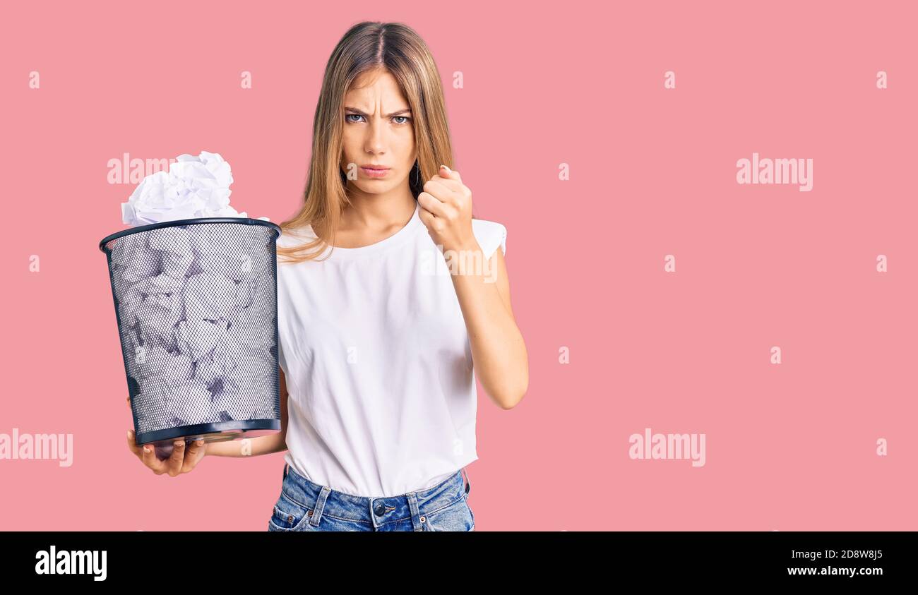 Beautiful caucasian woman with blonde hair holding paper bin full of ...