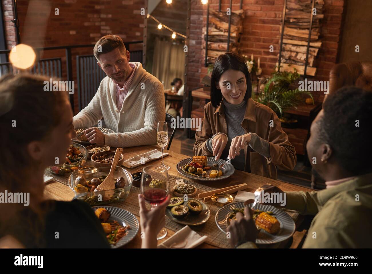 High angle view at group of cheerful adult people sitting at dinner ...