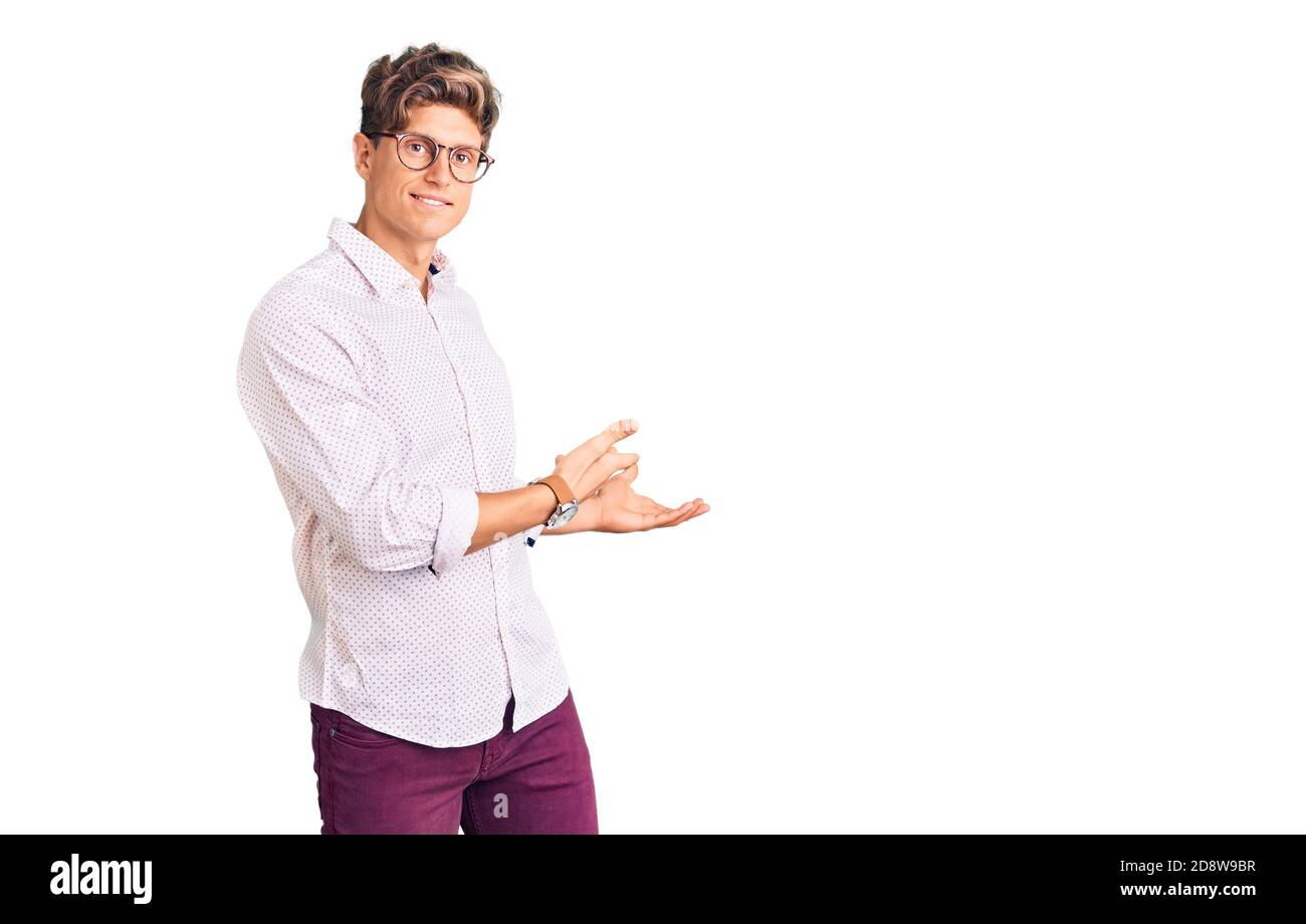 Young handsome man wearing business clothes and glasses inviting to ...
