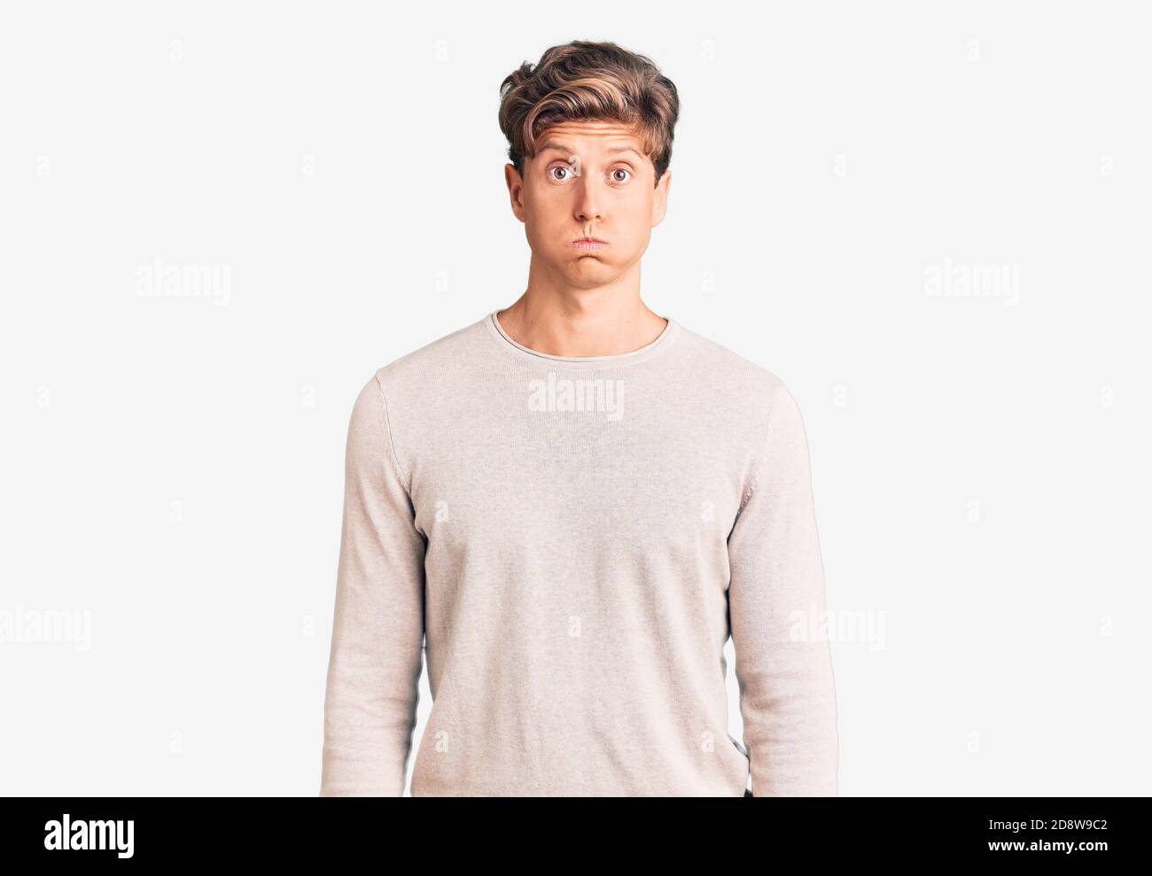 Young handsome man wearing casual clothes puffing cheeks with funny ...