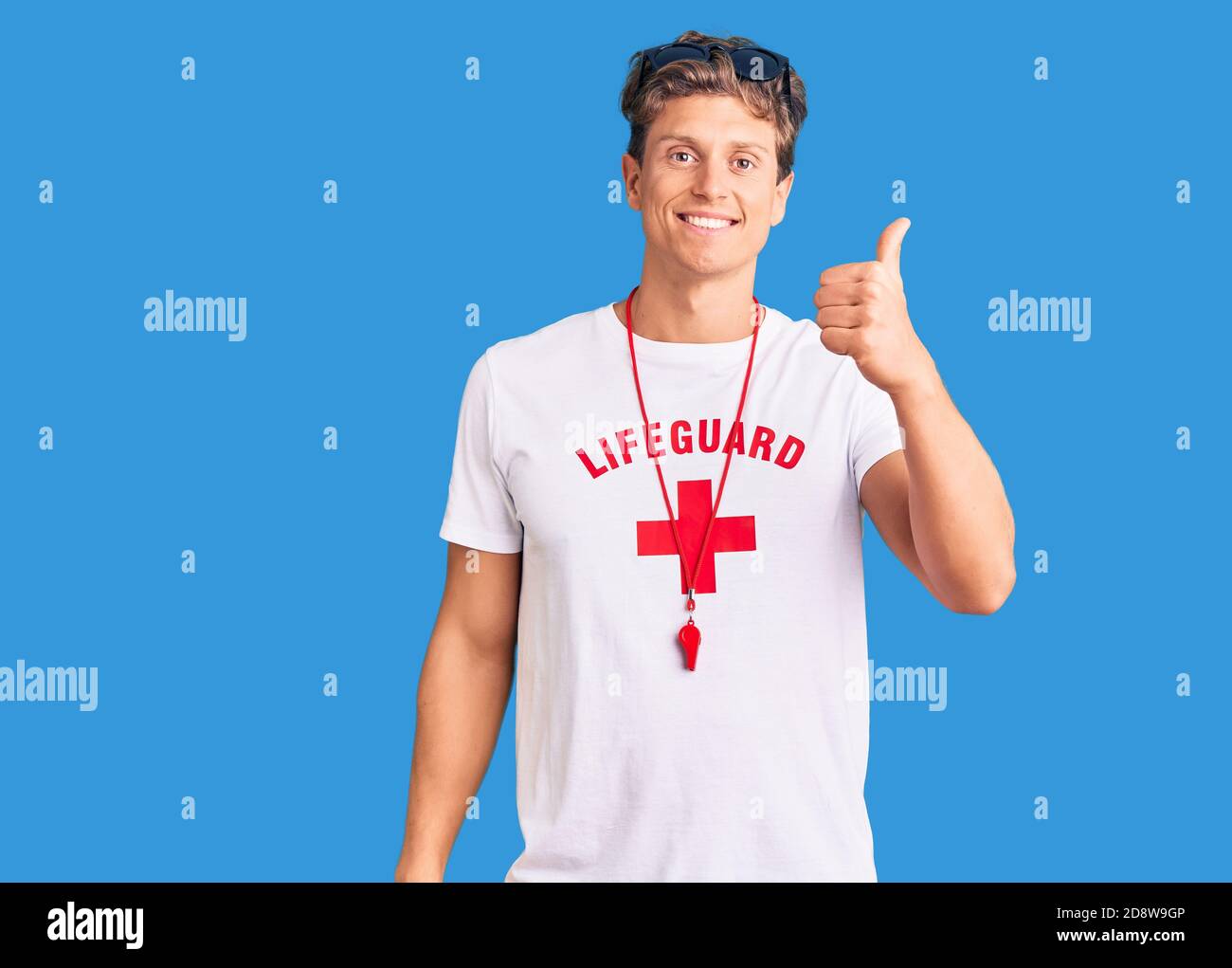 Young handsome man wearing lifeguard t shirt and whistle smiling happy ...