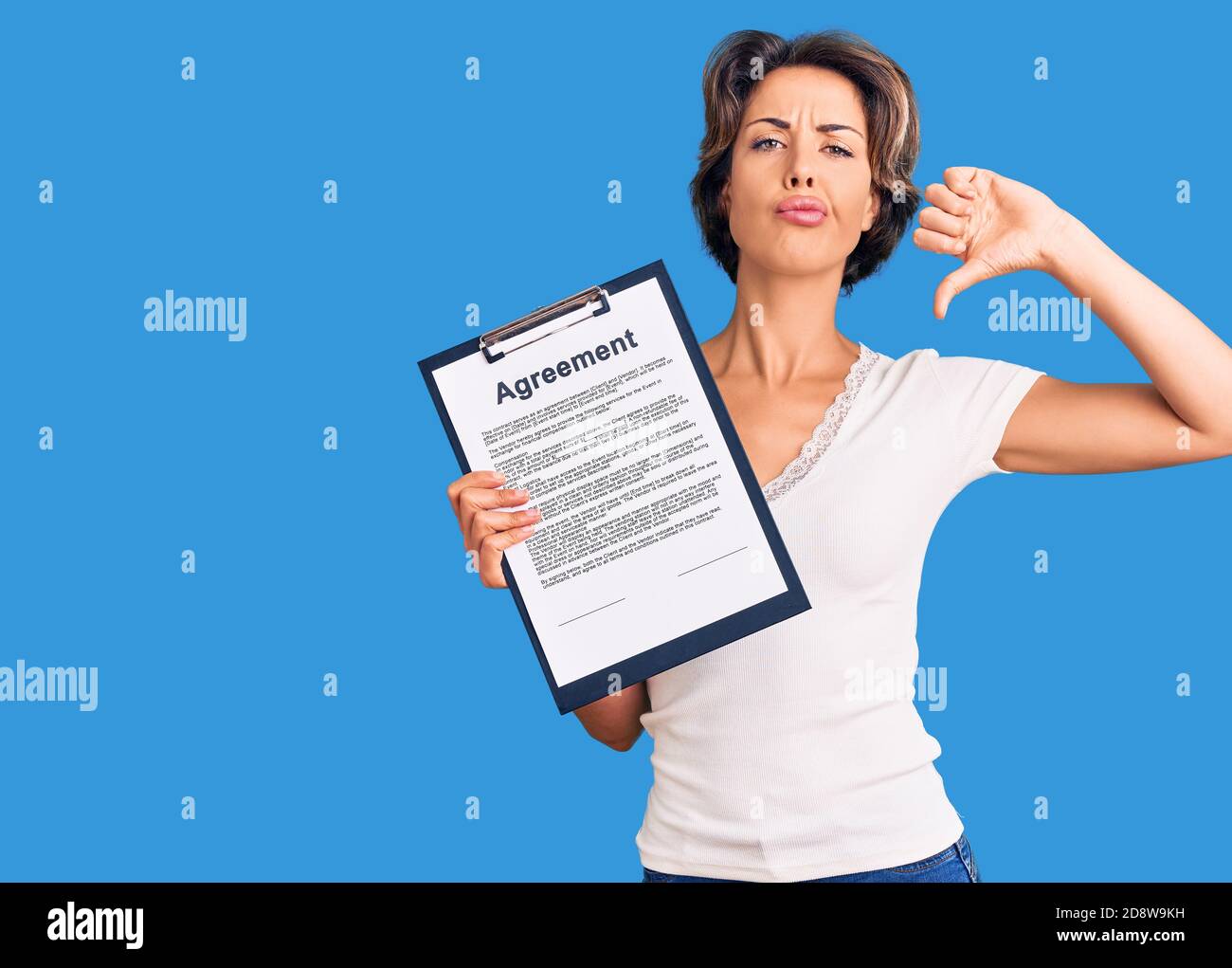 Young beautiful woman holding clipboard with agreement document with ...