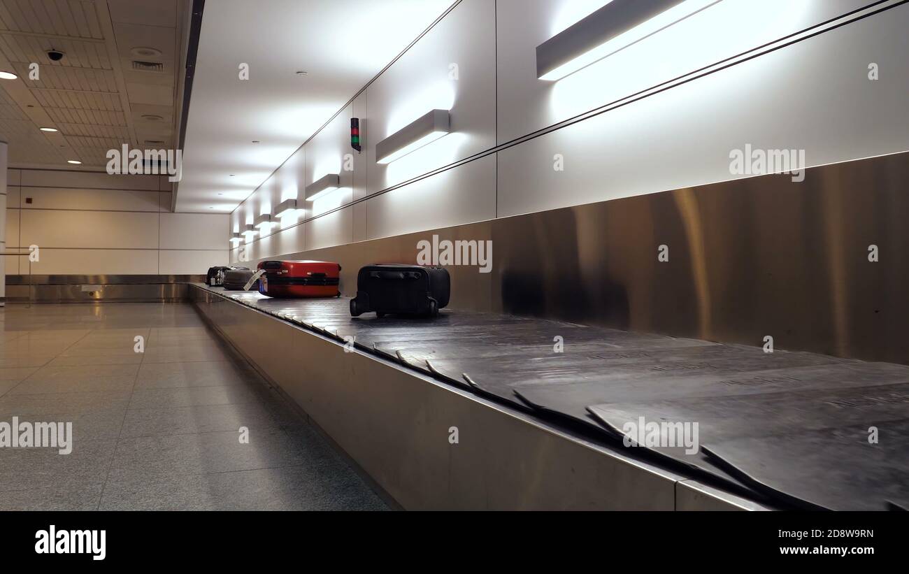 Suitcase or luggage is conveyed through the conveyor belt in arrivals ...