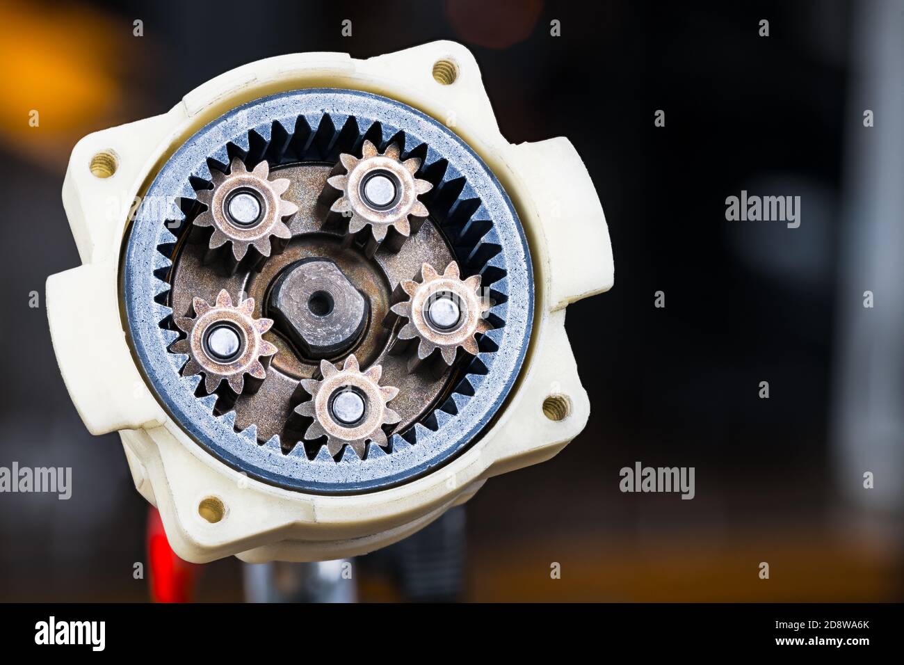 Metal cog wheels in open planetary gearbox of a power drill on dark ...