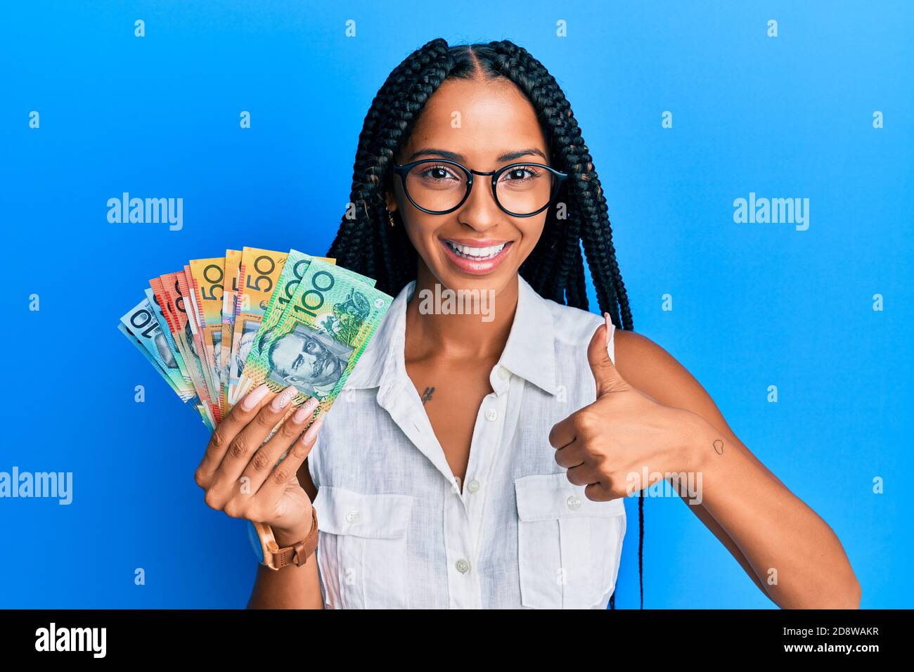 Beautiful hispanic woman holding australian dollars smiling happy and ...