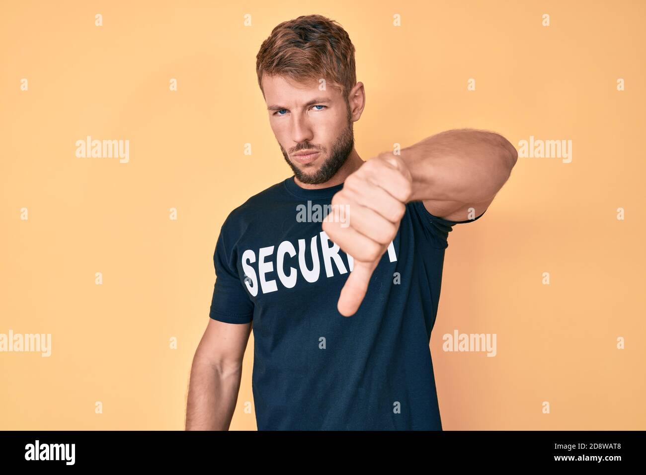 Young caucasian man wearing security t shirt looking unhappy and angry ...