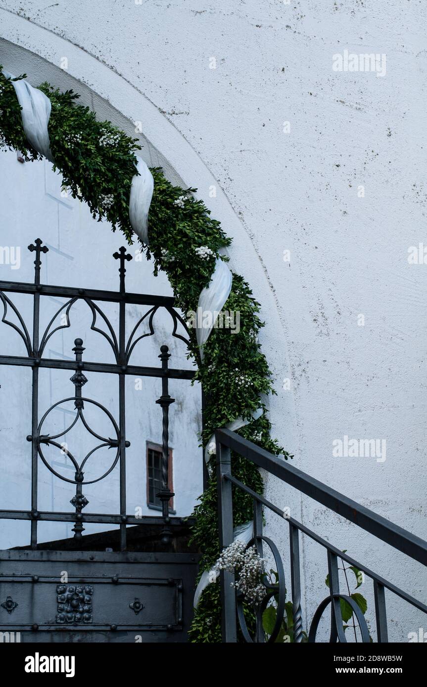 arched entrance to a church with a wrought iron gate decorated with box ...
