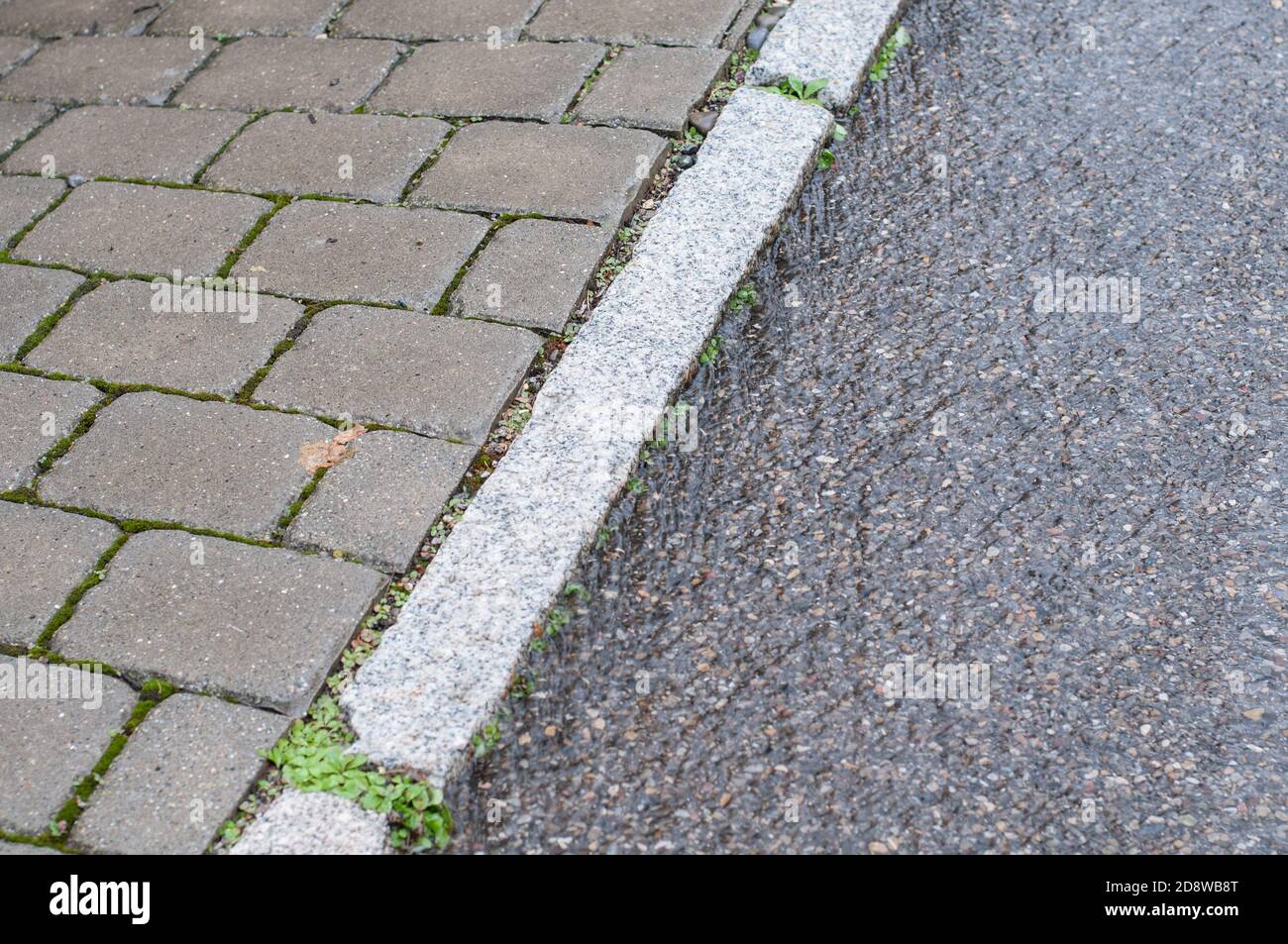 water flowing in ripples down an asphalt road on a rainy day Stock ...