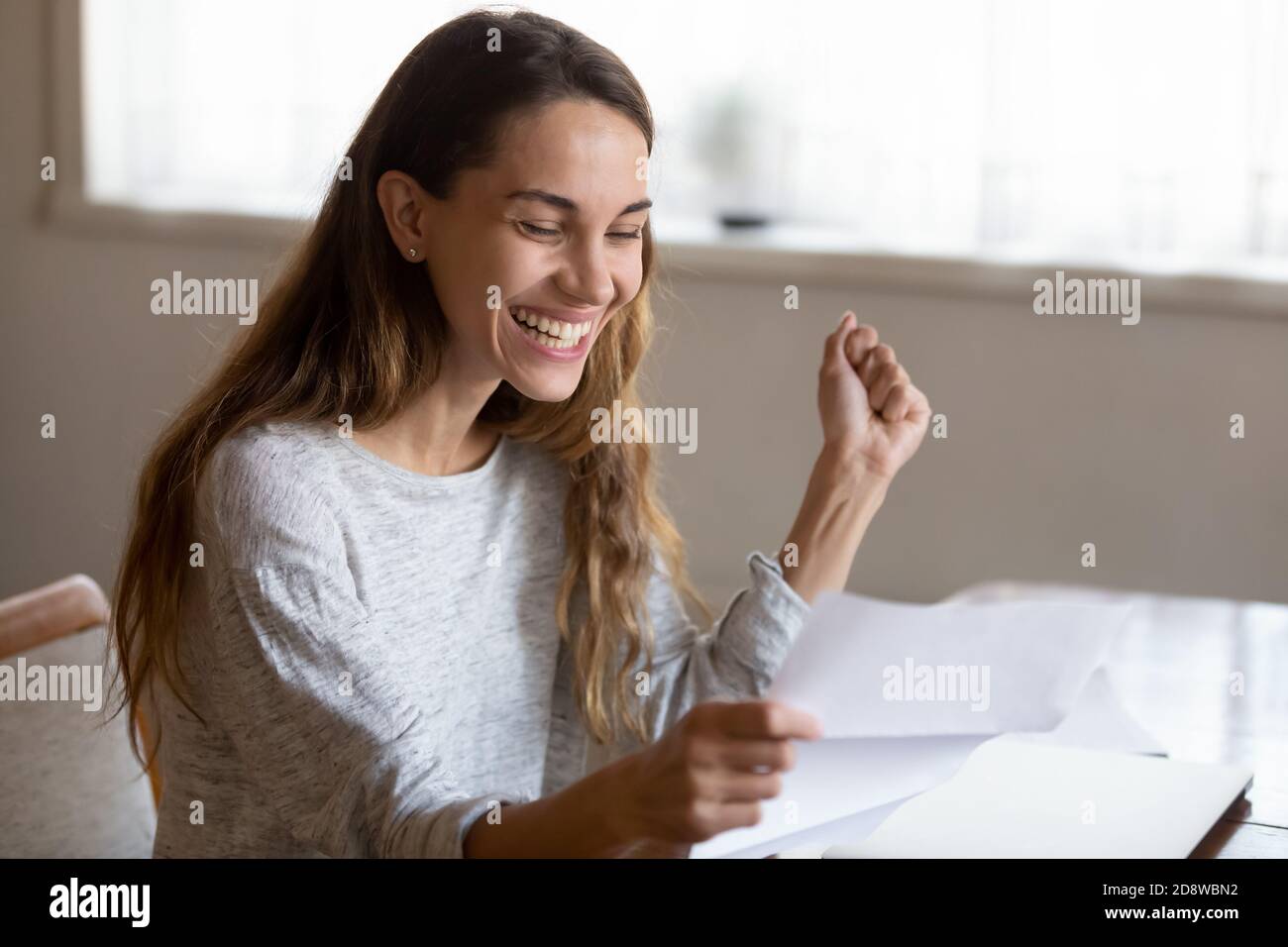 Excited young lady reading postal letter of loan request approval Stock ...