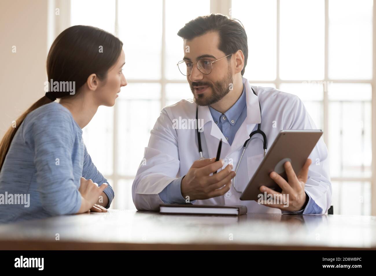 Capable general practitioner demonstrating patient test results in ...