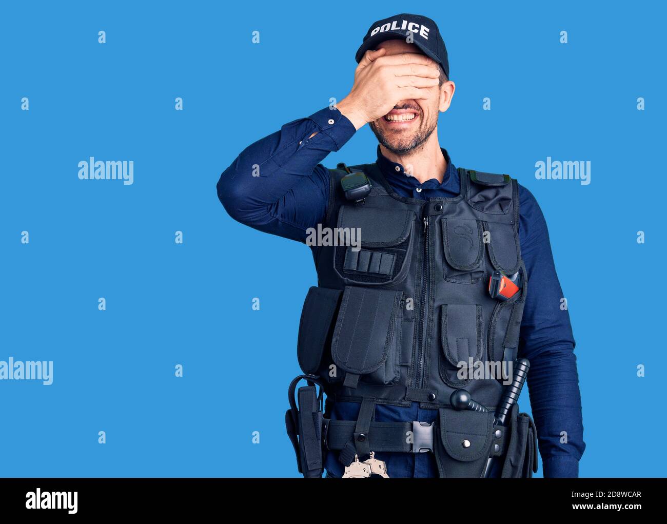 Young handsome man wearing police uniform smiling and laughing with ...