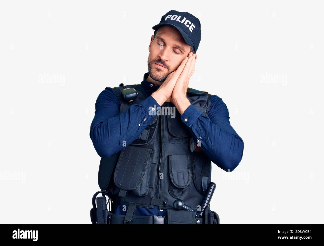 Young handsome man wearing police uniform sleeping tired dreaming and ...