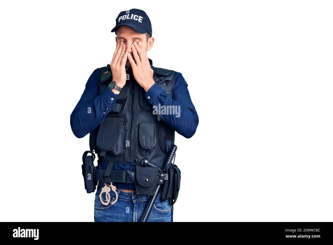 Young handsome man wearing police uniform rubbing eyes for fatigue and ...
