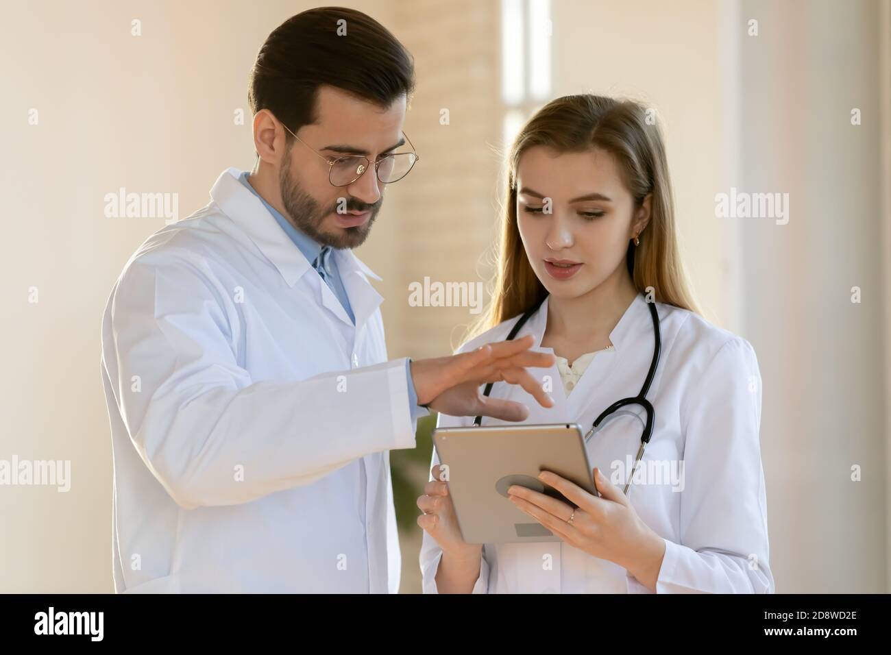 Experienced doctor sharing point of view with colleague using pad Stock ...