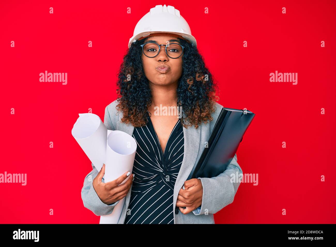 Young african american woman wearing architect hardhat holding binder ...