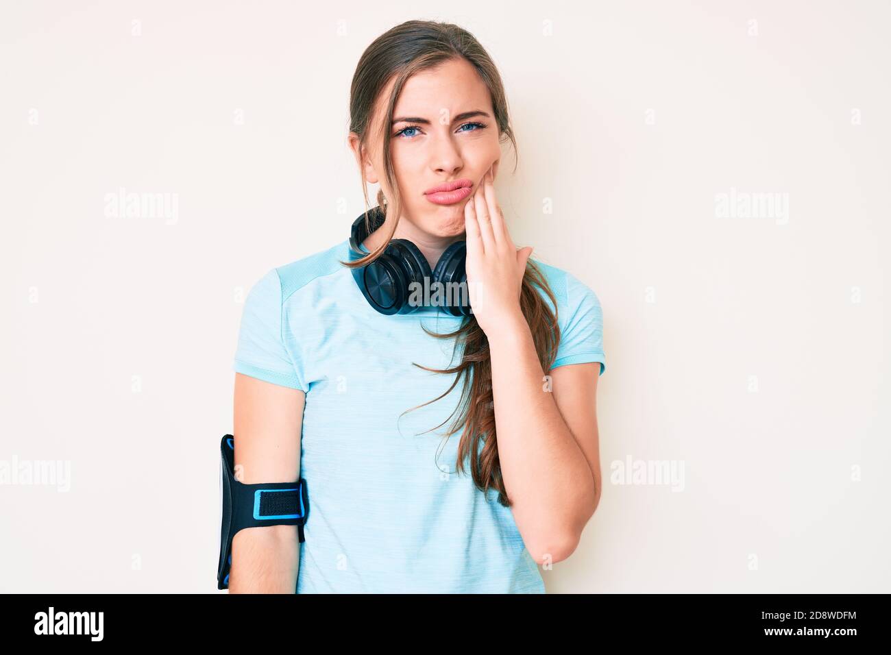 Beautiful young caucasian woman wearing gym clothes and using ...