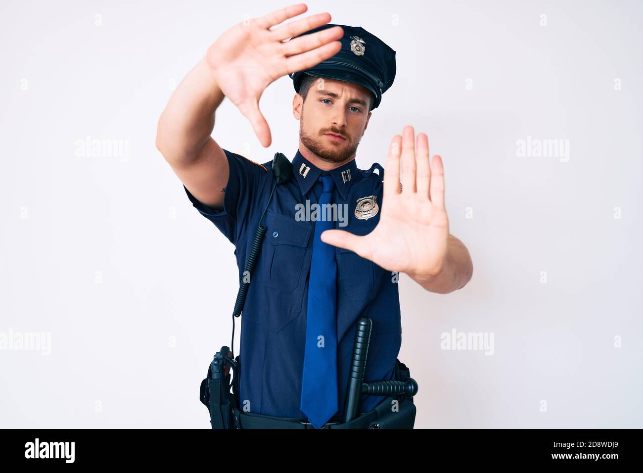 Young caucasian man wearing police uniform doing frame using hands ...