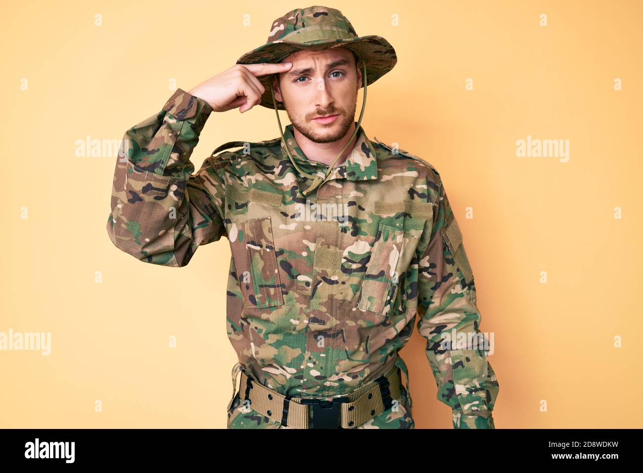 Young caucasian man wearing camouflage army uniform pointing unhappy to ...
