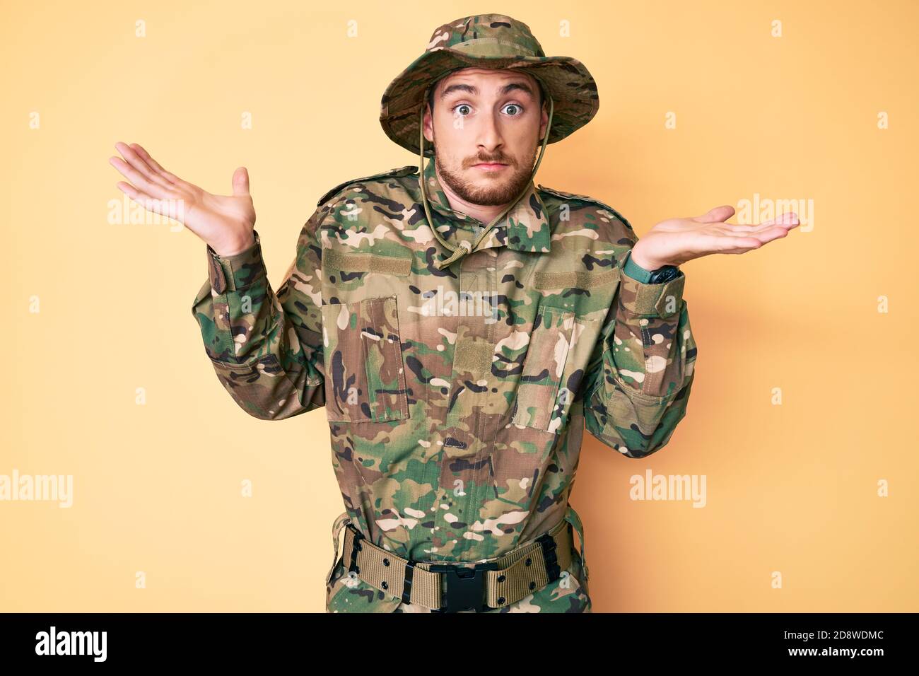 Young caucasian man wearing camouflage army uniform clueless and ...