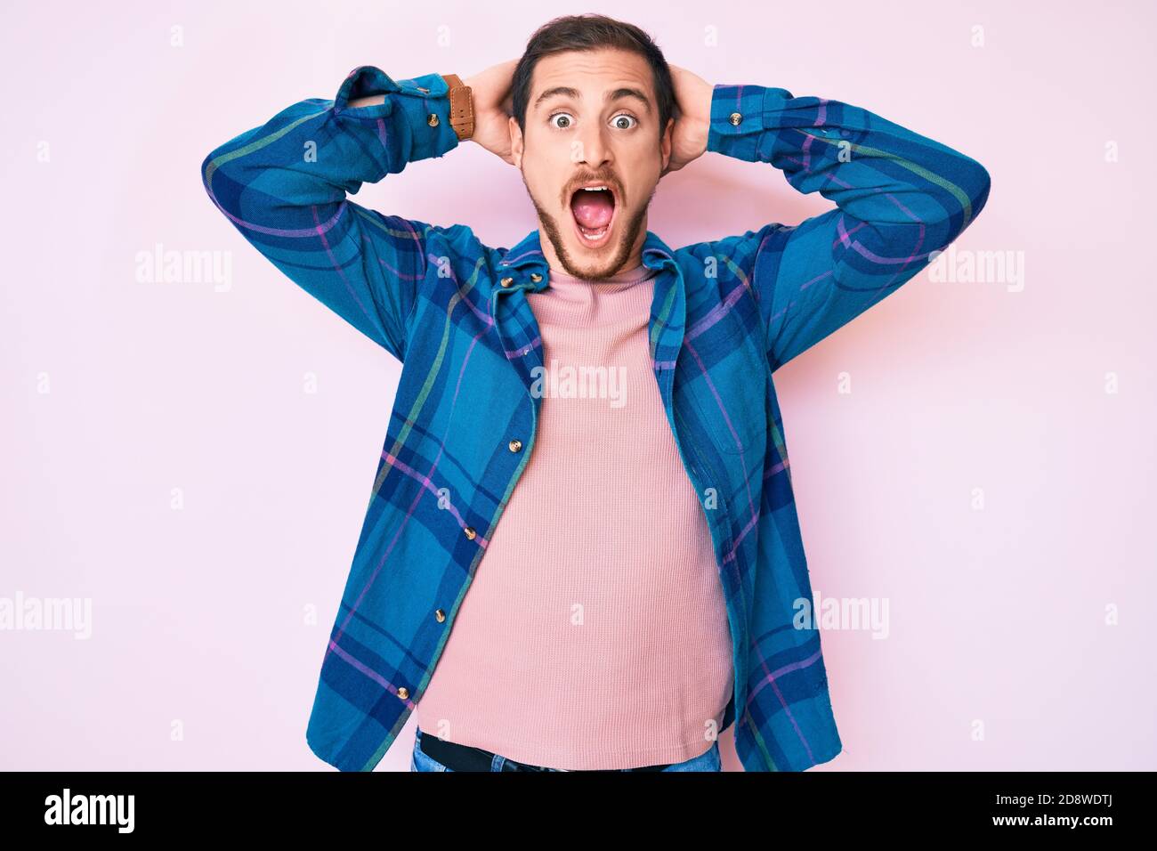 Young handsome man wearing casual clothes crazy and scared with hands ...