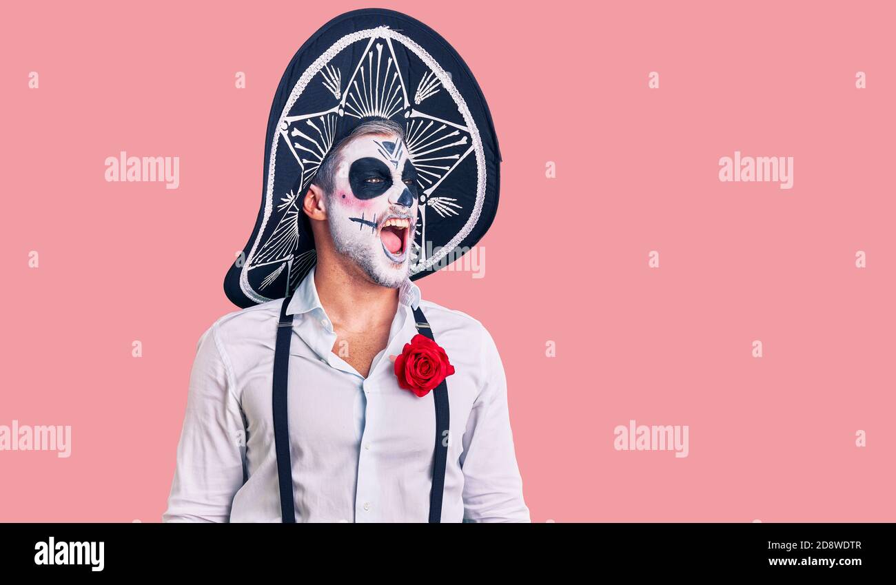 Man wearing day of the dead costume over background angry and mad ...