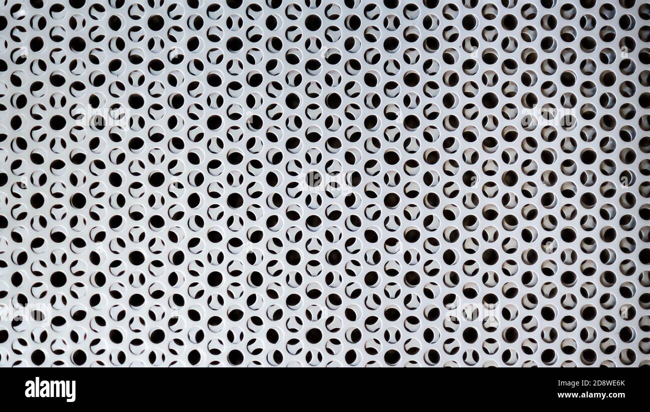 Rusty silver metal background with round holes. Metal texture with ...