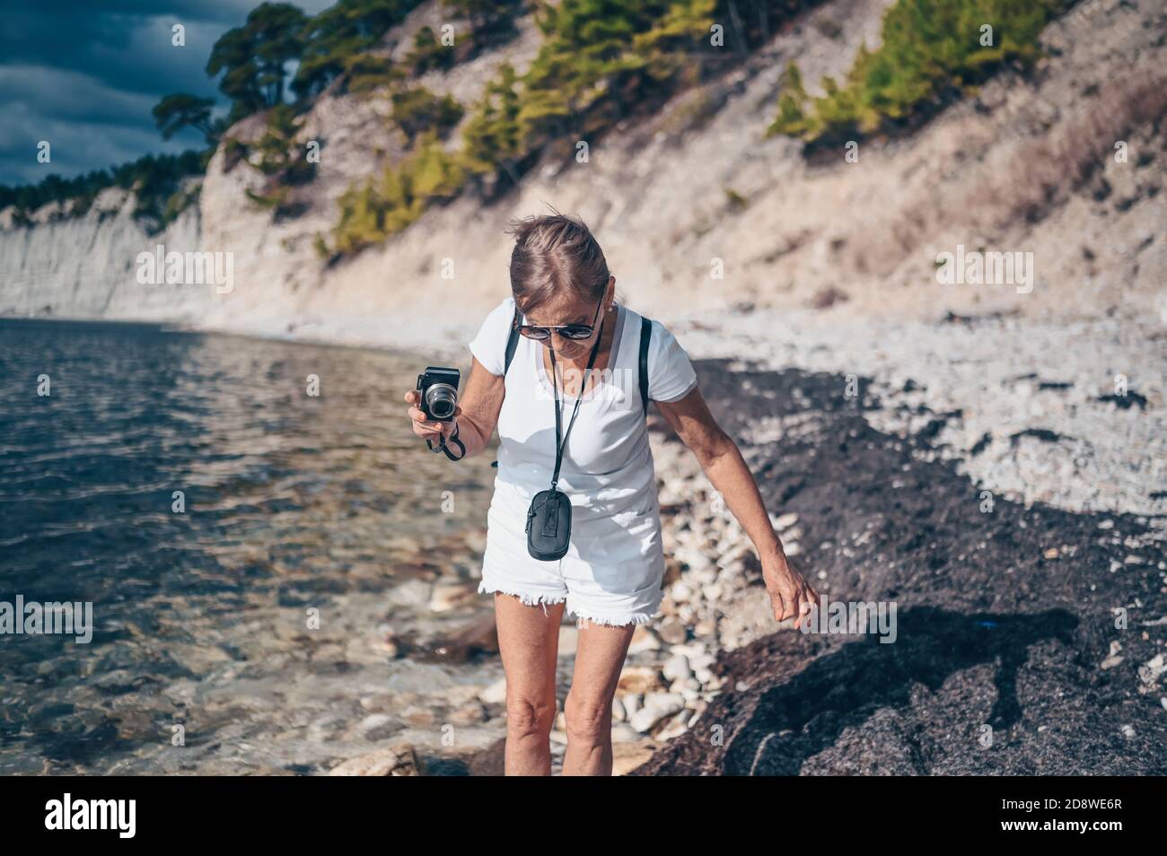 Elderly senior traveling backpacker mature woman tourist walking taking ...