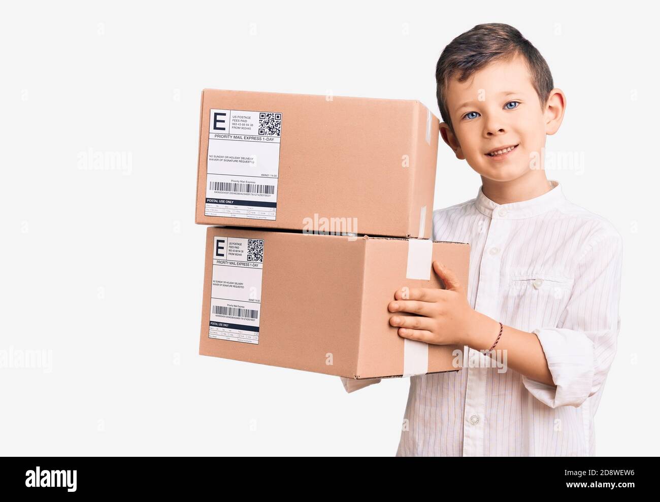 Cute blond kid holding delivery package looking positive and happy ...