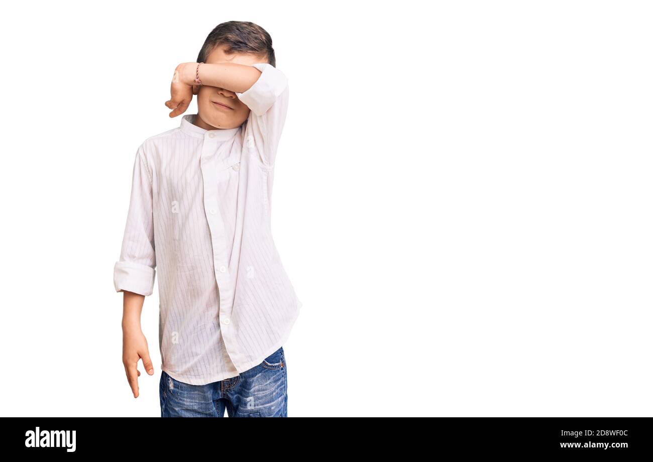 Cute blond kid wearing elegant shirt covering eyes with arm, looking ...