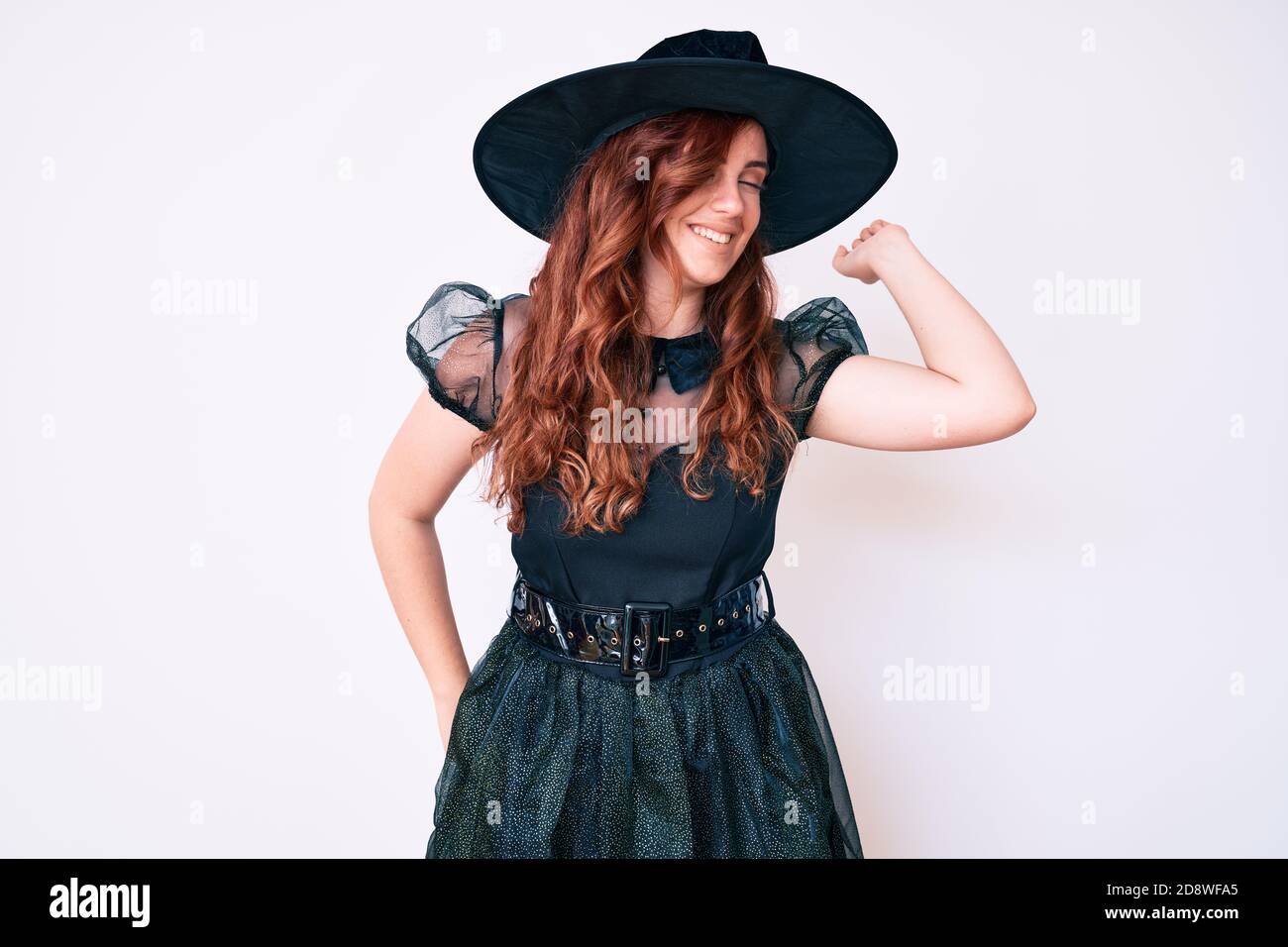 Young beautiful woman wearing witch halloween costume stretching back ...