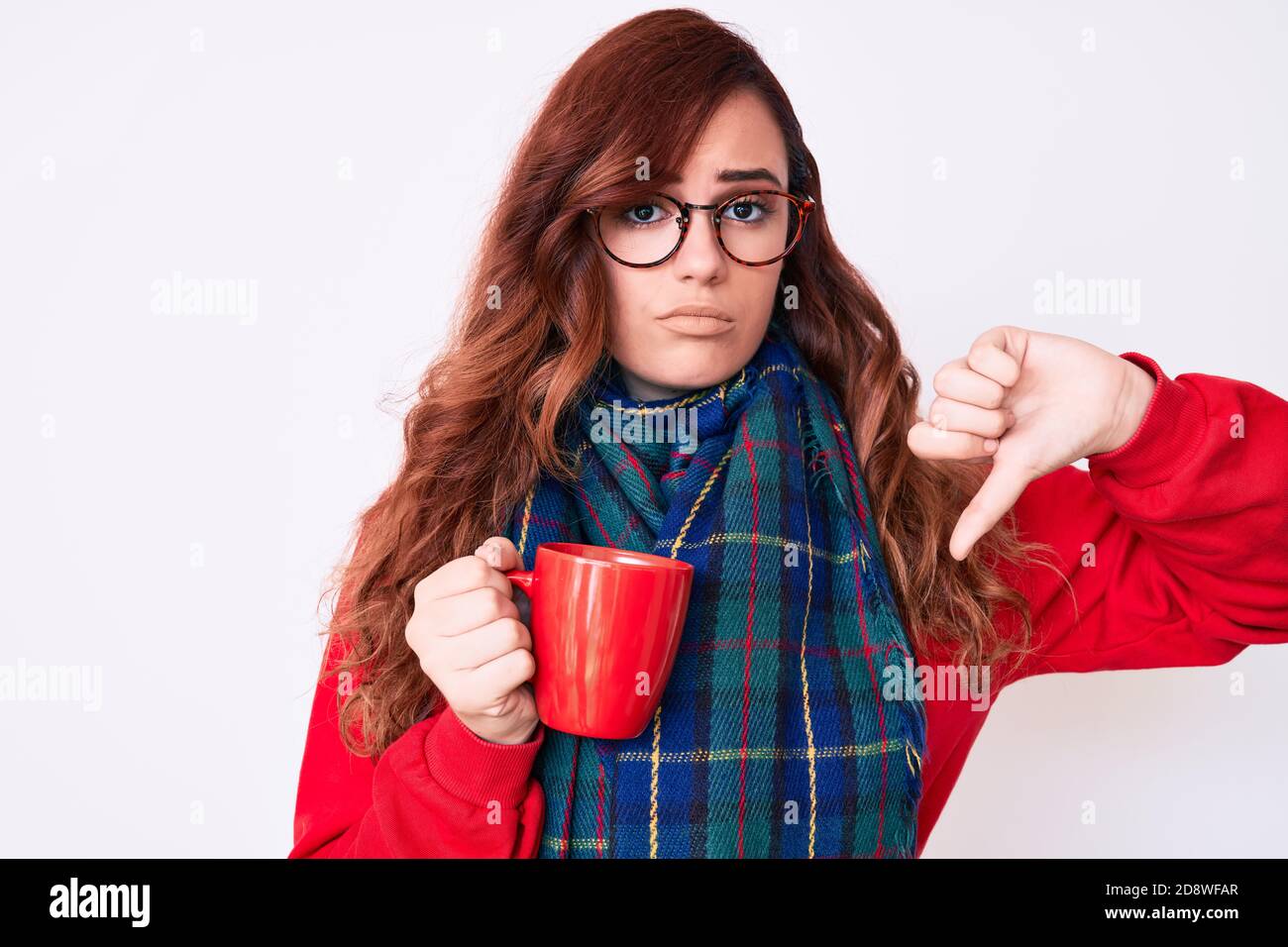 Young beautiful woman wearing winter scarf and drinking a cup of hot ...