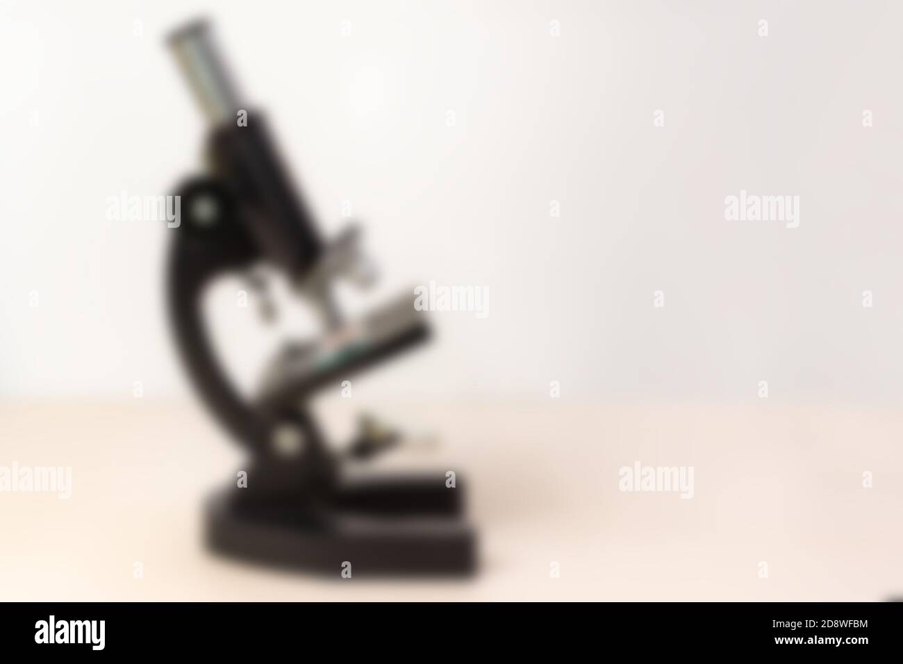 A blur of a lab microscope. Microscopy is tilted back. White and creme ...