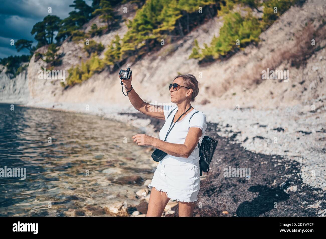 Elderly senior traveling backpacker mature woman tourist walking taking ...
