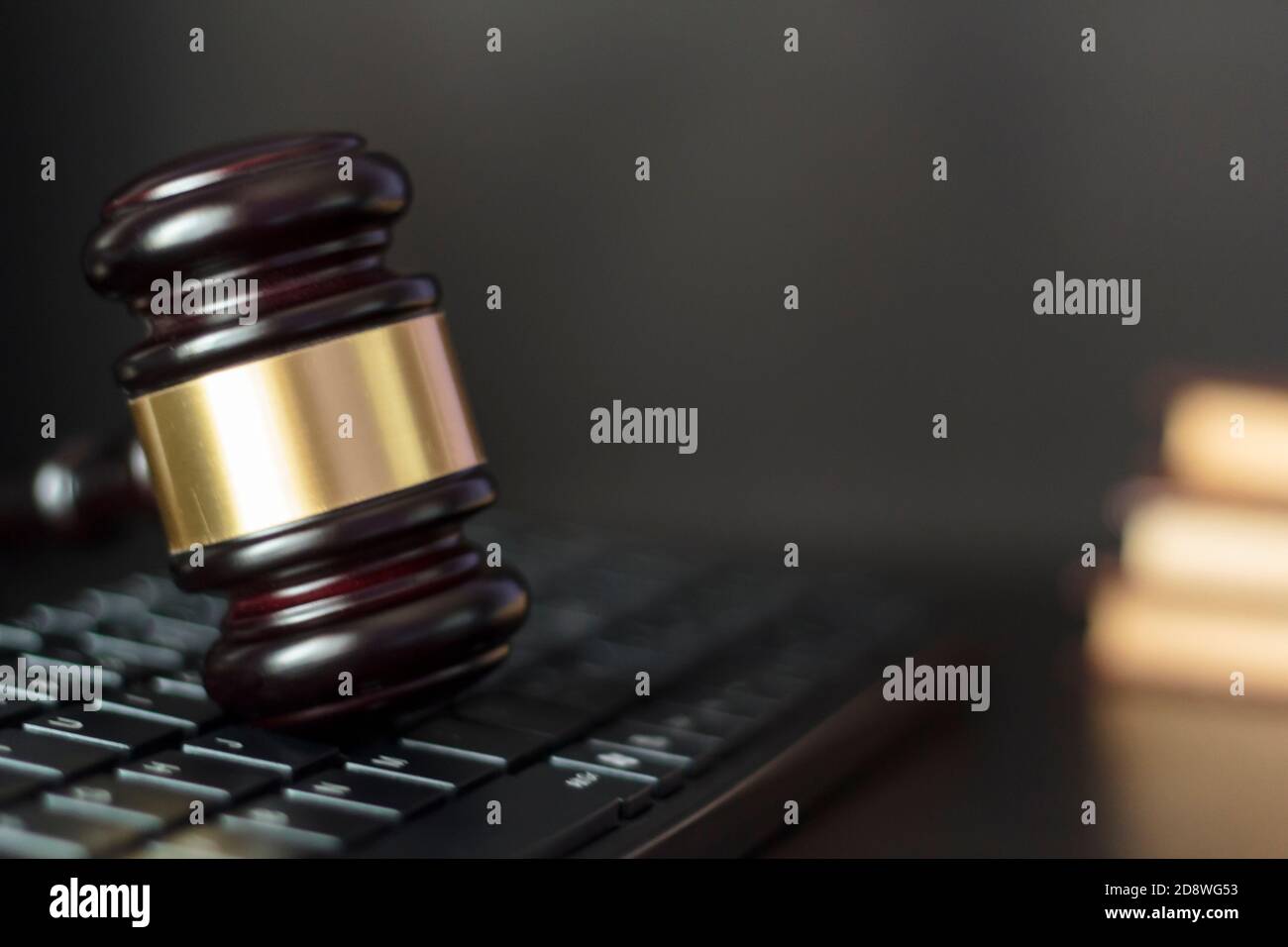 Judge's gavel on computer keyboard with copy space with law books on ...