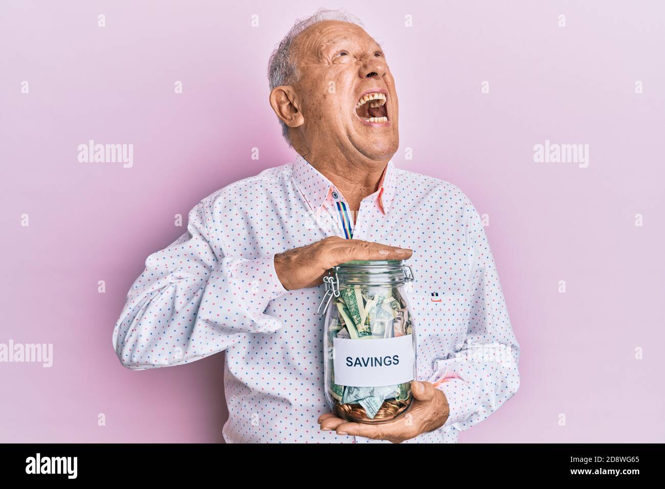 Senior caucasian man holding jar with savings angry and mad screaming ...