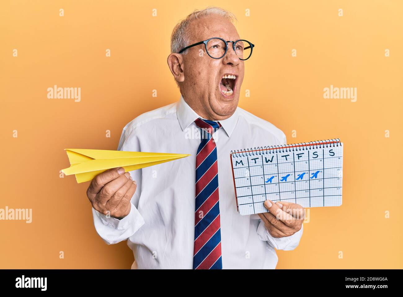 Senior caucasian man going on business trip holding paper airplane ...