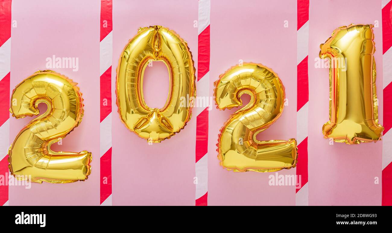 2021 gold balloons with warning tape on pink background for keeping ...