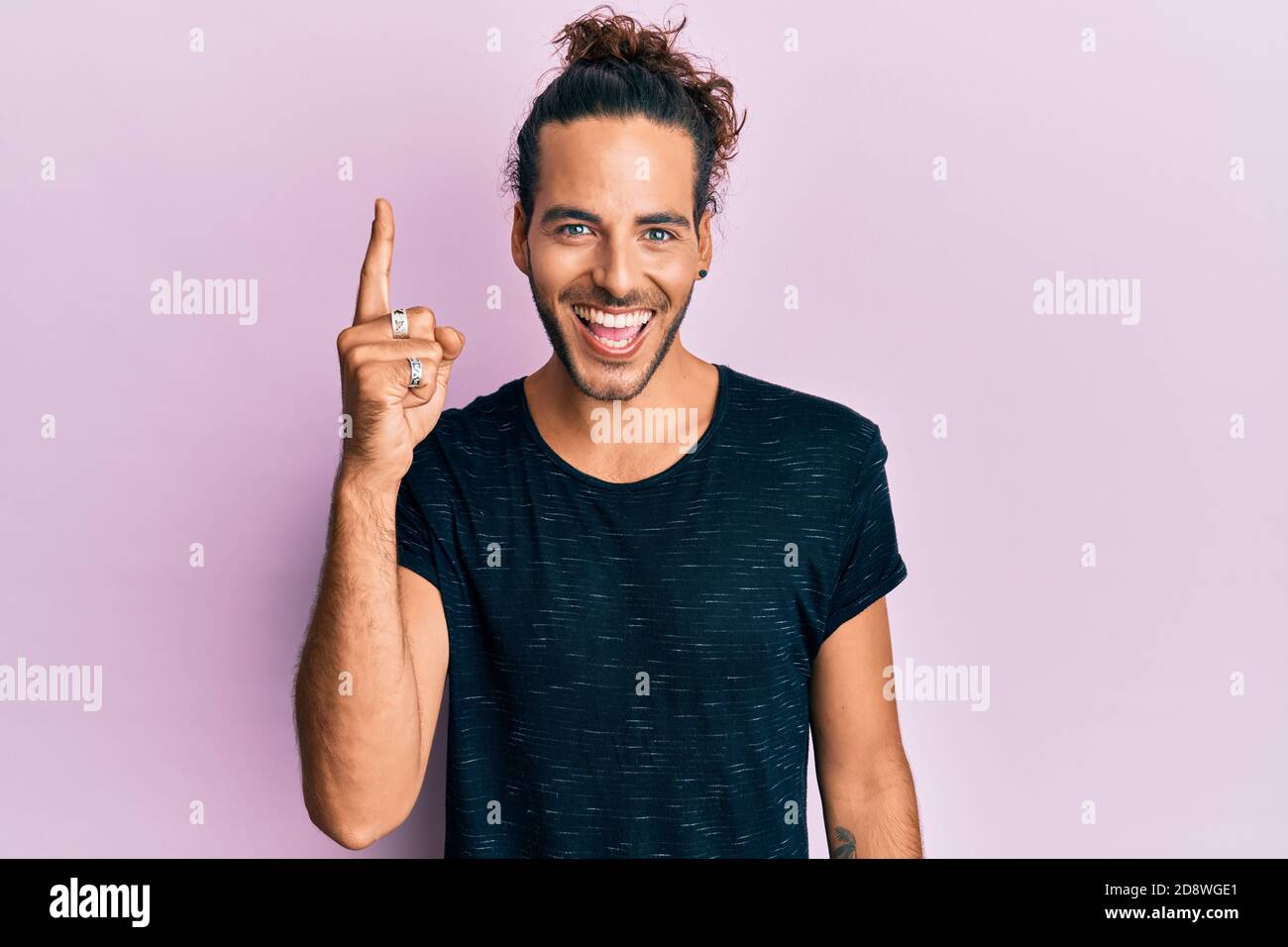 Young handsome man with long hair wearing casual clothes pointing ...