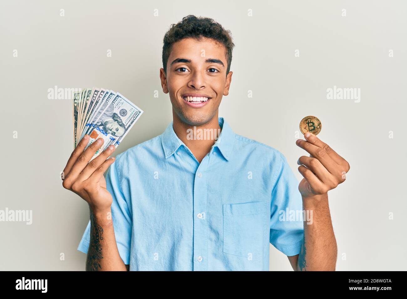 Young handsome african american man holding virtual currency bitcoin ...
