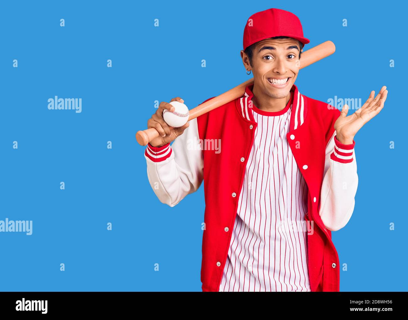 Young african amercian man playing baseball holding bat and ball ...