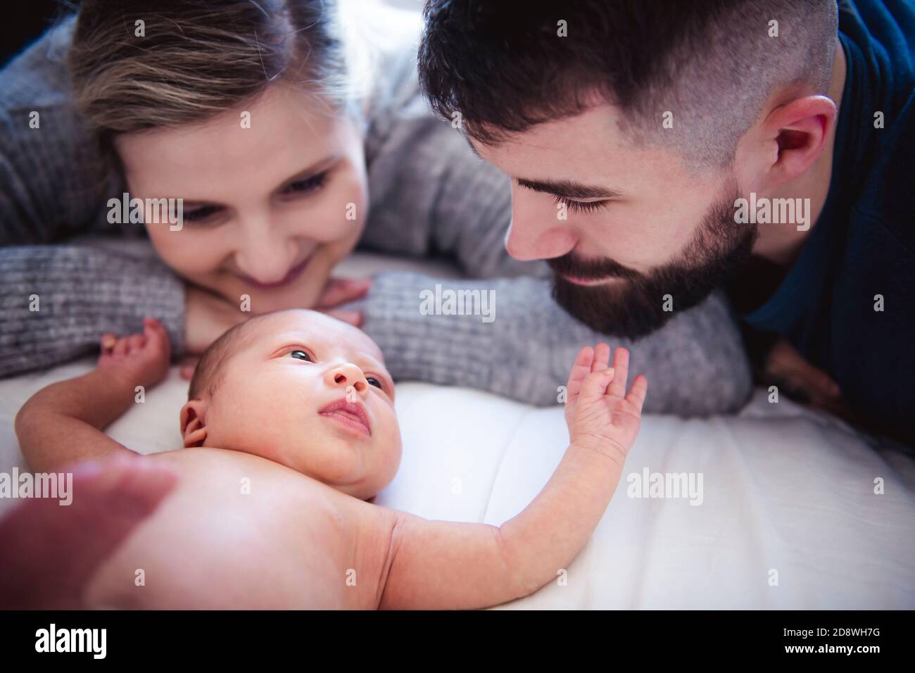 family lay on bed with his newborn baby daughter Stock Photo - Alamy