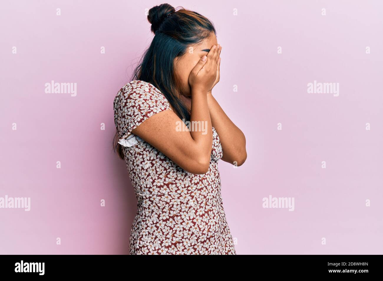 Young latin woman wearing casual clothes with sad expression covering ...