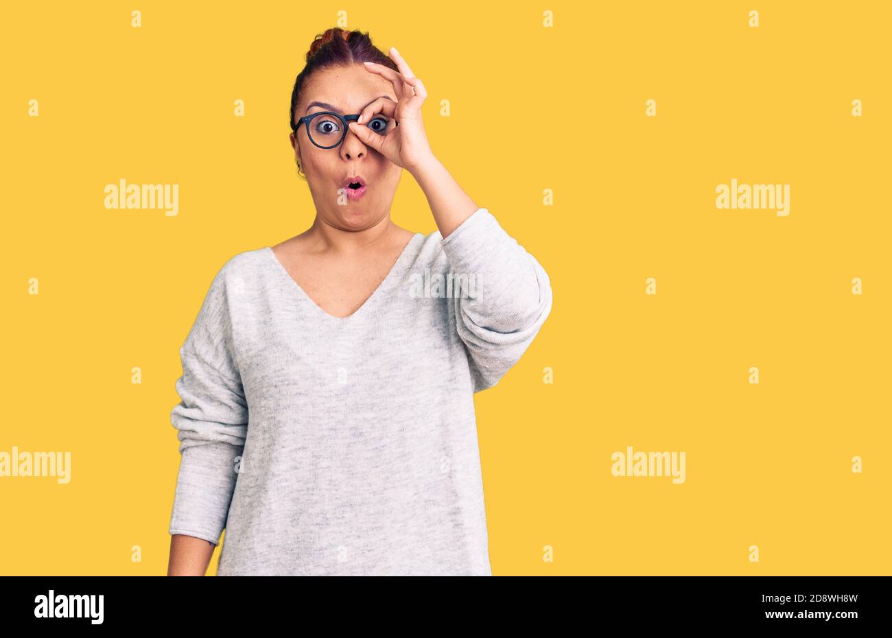 Young latin woman wearing casual clothes doing ok gesture shocked with ...