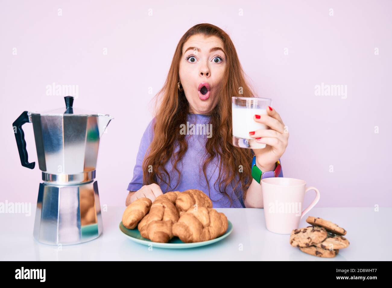 Young redhead woman eating breakfast looking stressed and nervous with ...